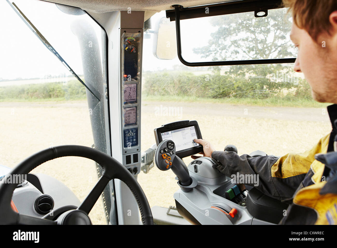 Farmer driving tractor in field Stock Photo - Alamy