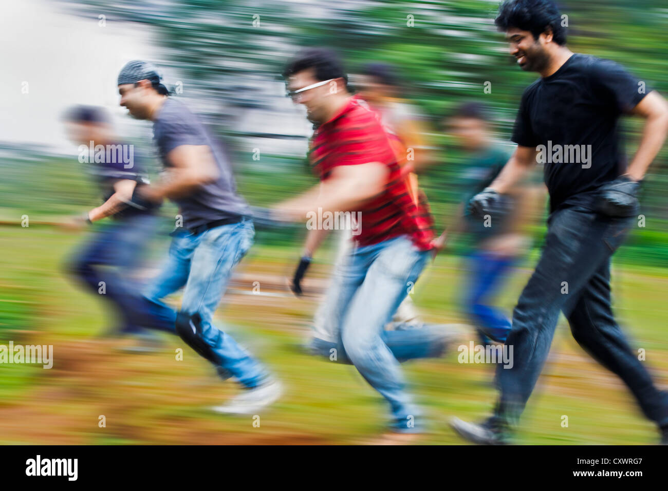 Generic motion blur of motor Indian men racing for fun over grassy lawn ...