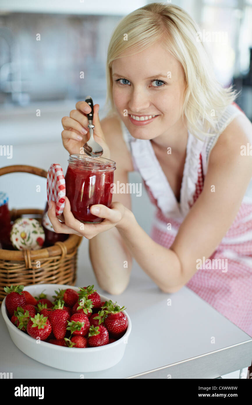 Woman eating jelly from jar in kitchen Stock Photo - Alamy