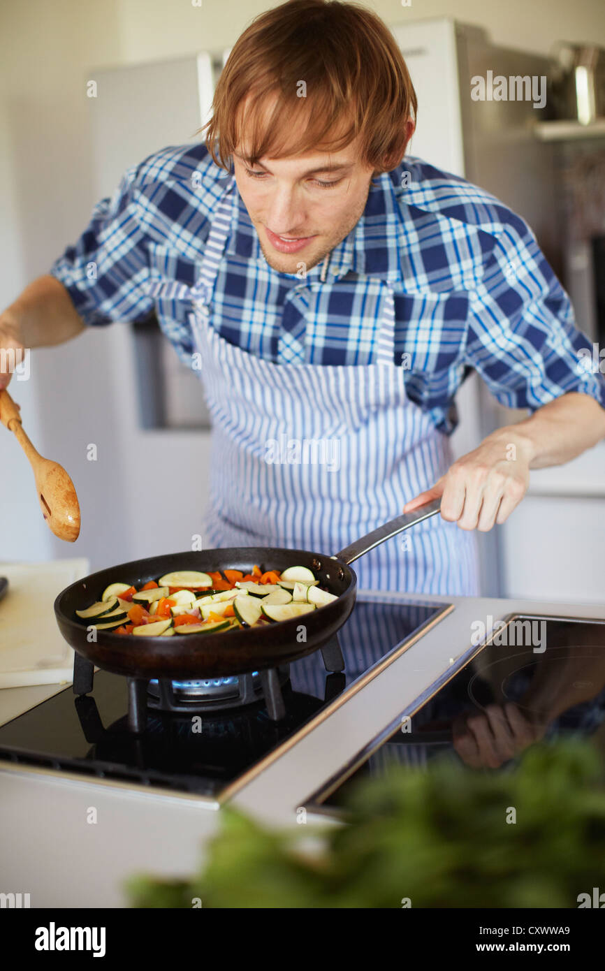 Man frying vegetables in kitchen Stock Photo - Alamy
