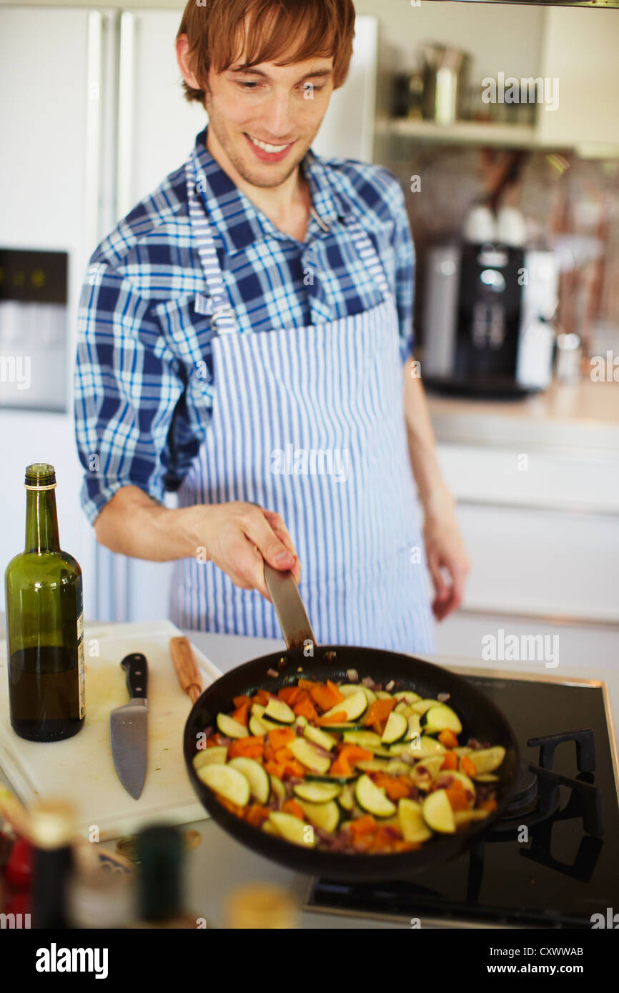 Man frying vegetables in kitchen Stock Photo - Alamy