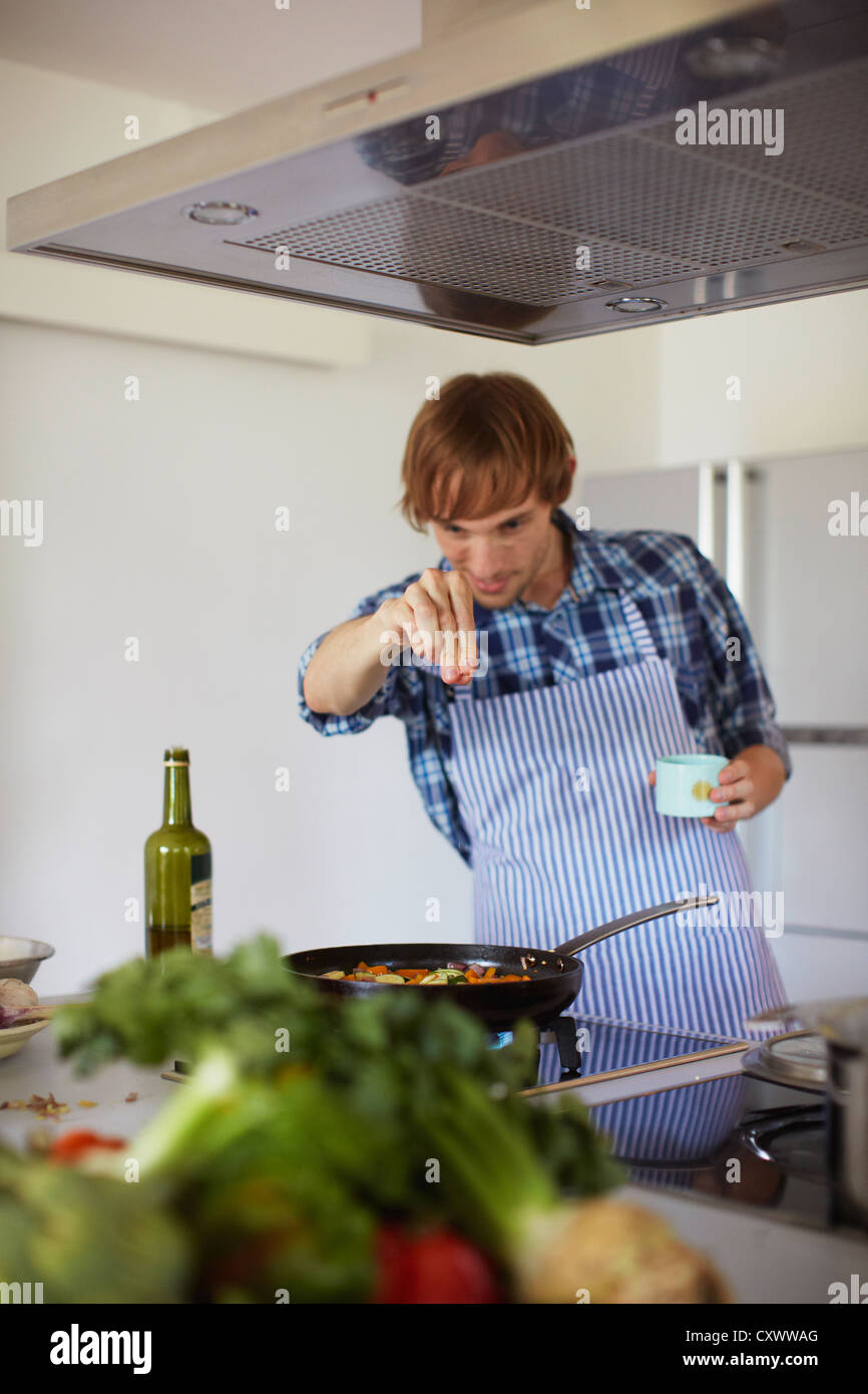 Man sprinkling spices on cooking Stock Photo - Alamy