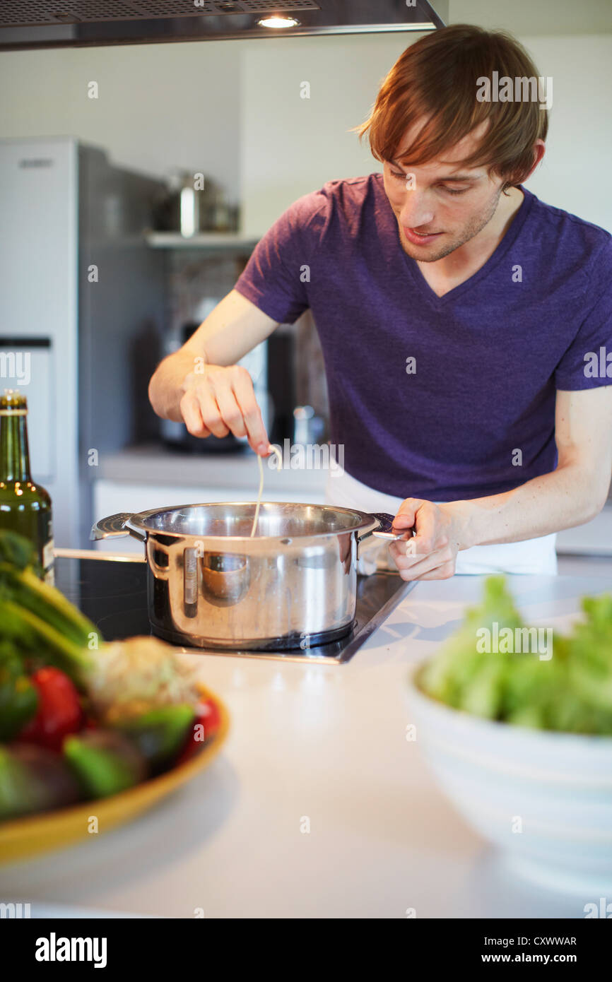 Man tasting pasta in kitchen Stock Photo - Alamy