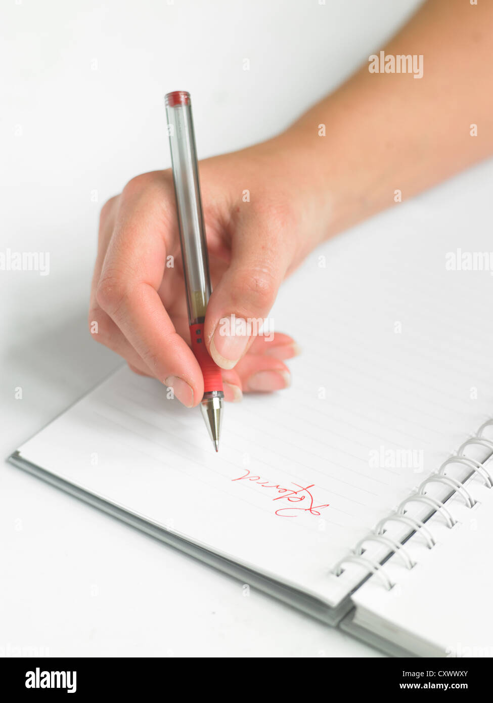 female hand writing in book with ball point pen Stock Photo - Alamy