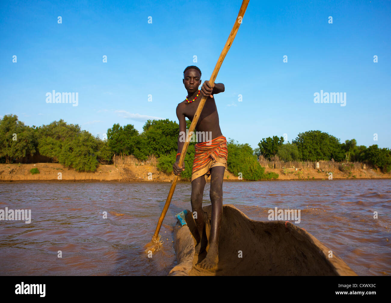 Young Boy Pushing A Boat On The Omo River, Omorate, Omo Valley ...