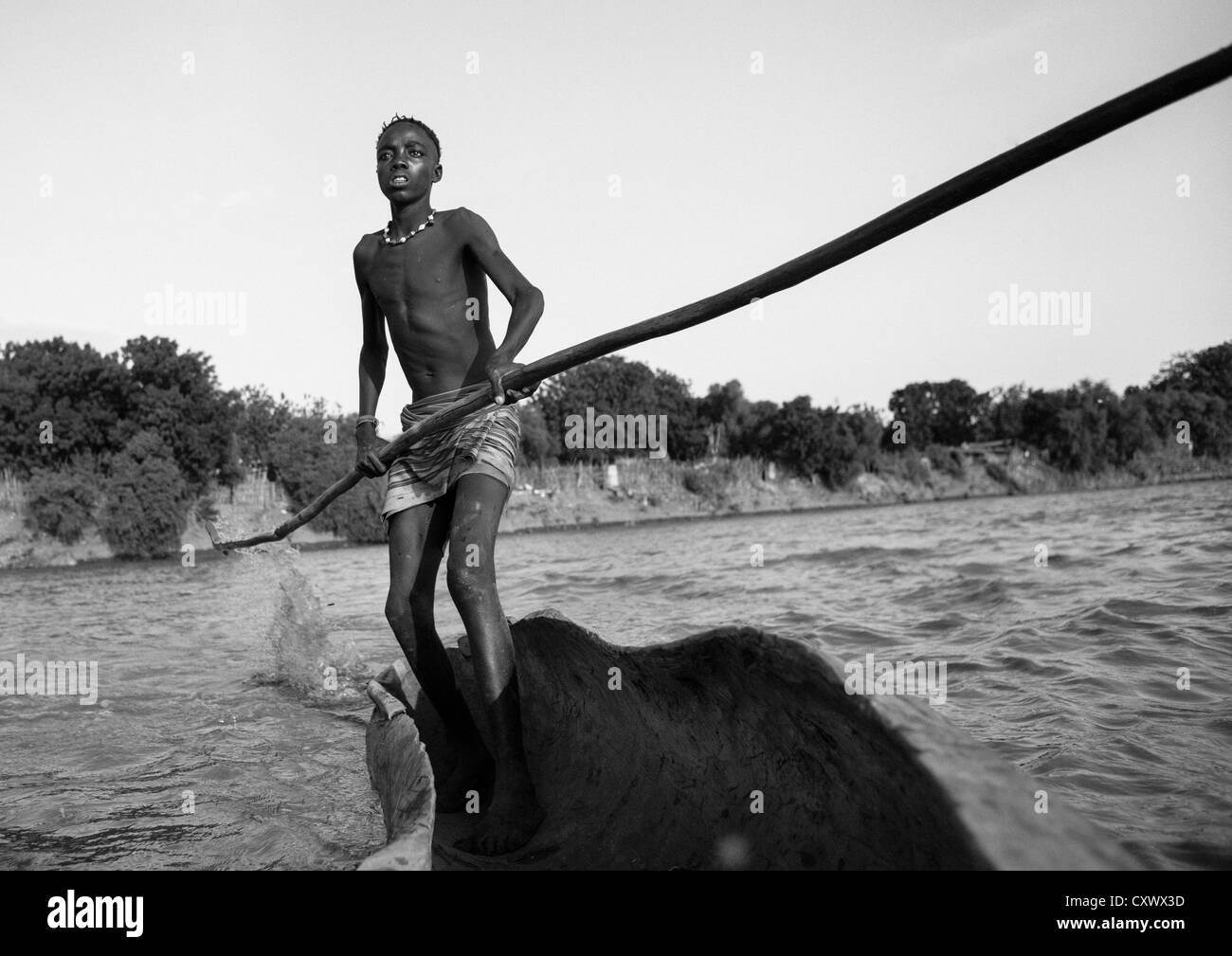 Young Boy Pushing A Boat On The Omo River, Omorate, Omo Valley ...