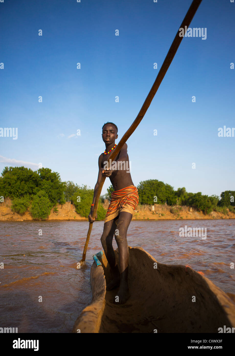 Young Boy Pushing A Boat On The Omo River, Omorate, Omo Valley ...