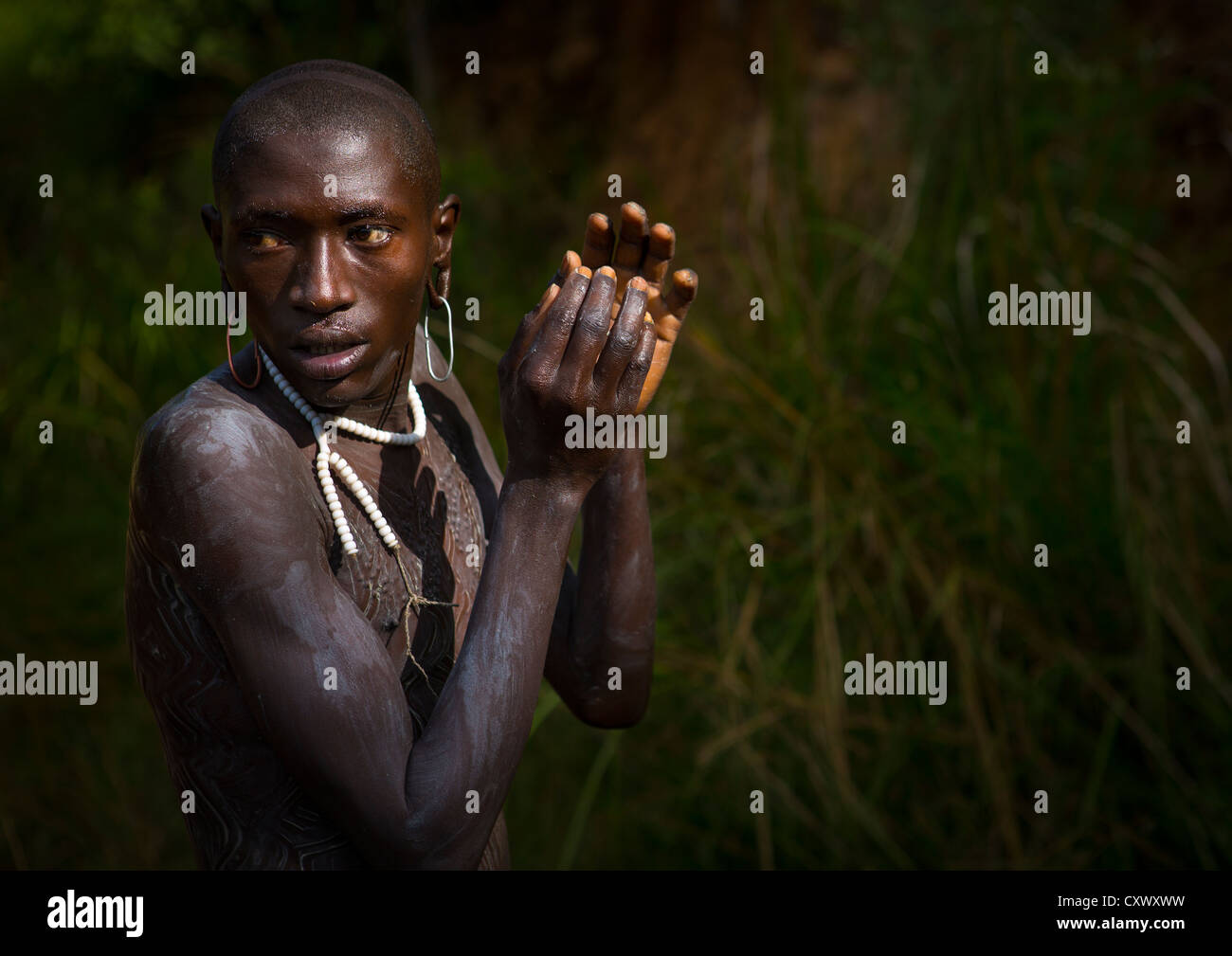 Shepherd From Suri Tribe Decorating His Body With Camouflage Paintings ...