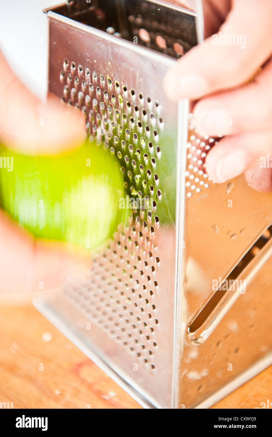 Closeup of grater with hand grating lime peel Stock Photo - Alamy