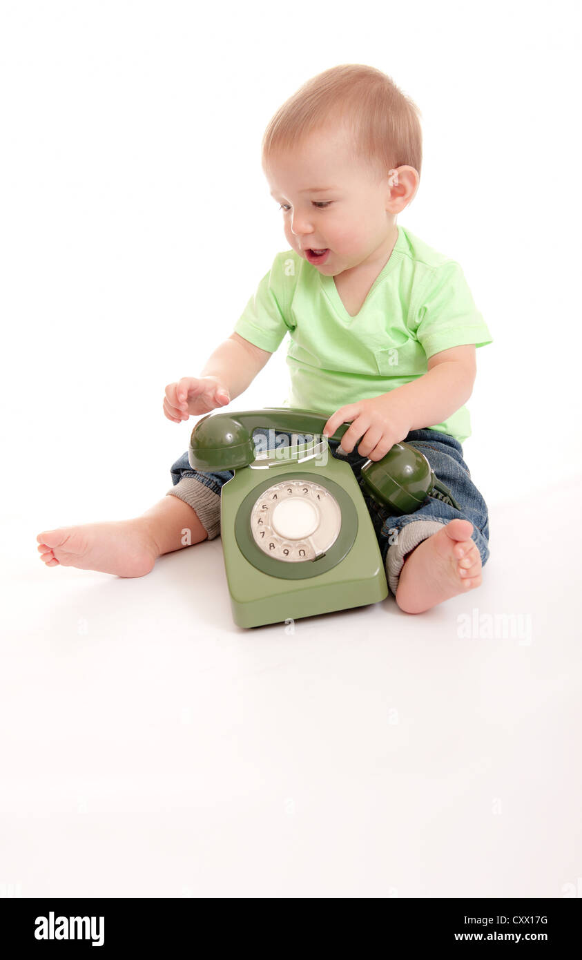 Small boy with old green telephone. Studio shot using a white ...