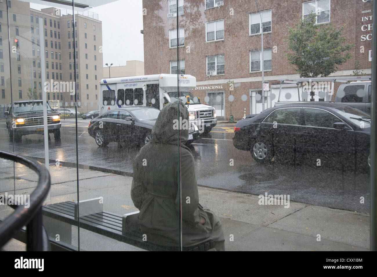 Young woman waits for a bus on a rainy day by the Prospect Park Parade ...
