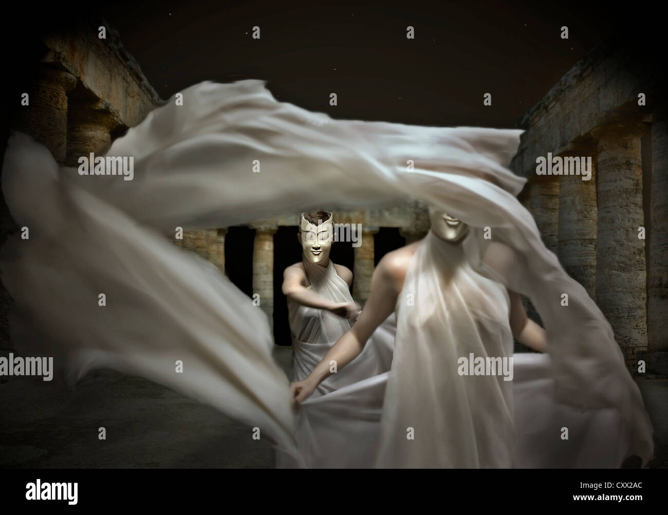 Two dancers wearing masks dance with flowing white cloth in a Roman ...