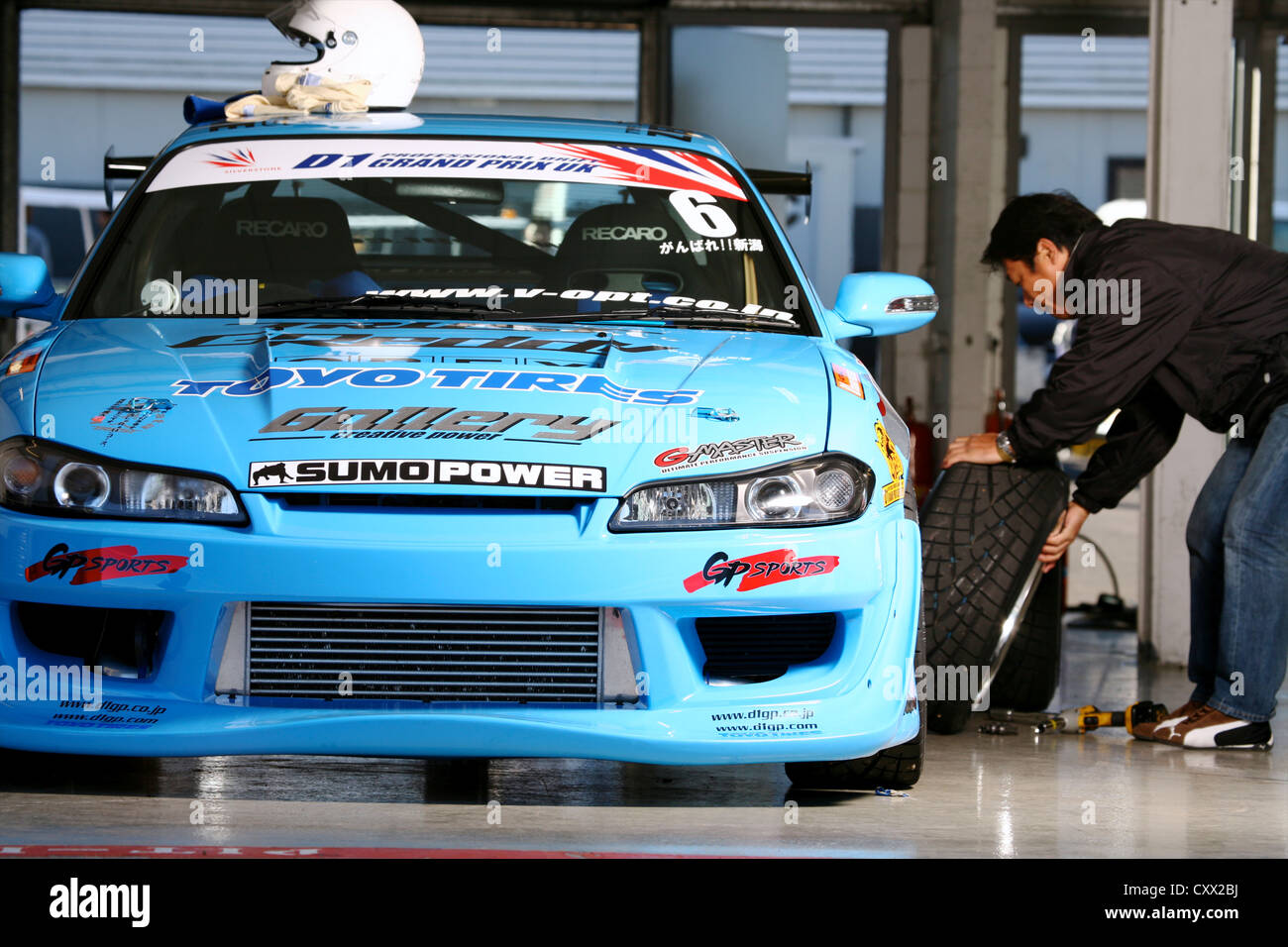 Team mechanic changing tyre on race car Stock Photo - Alamy