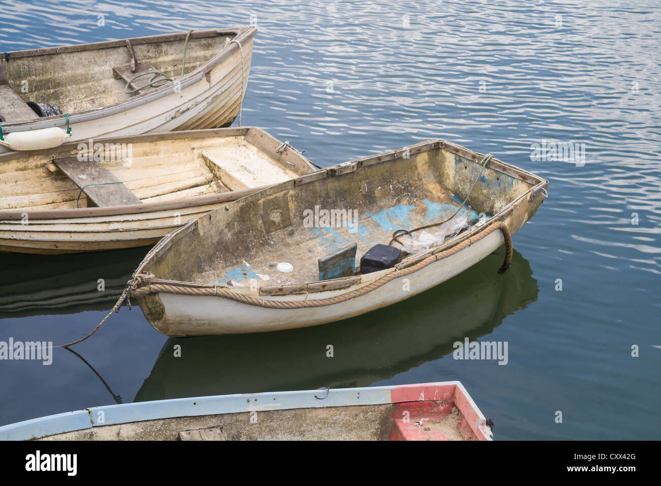 A small tethered rowing boat tethered to the dock Stock Photo - Alamy