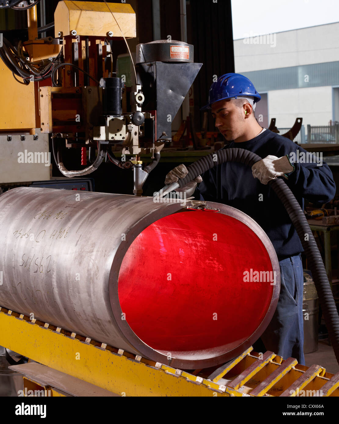 Caucasian worker working on steel pipe in factory Stock Photo - Alamy