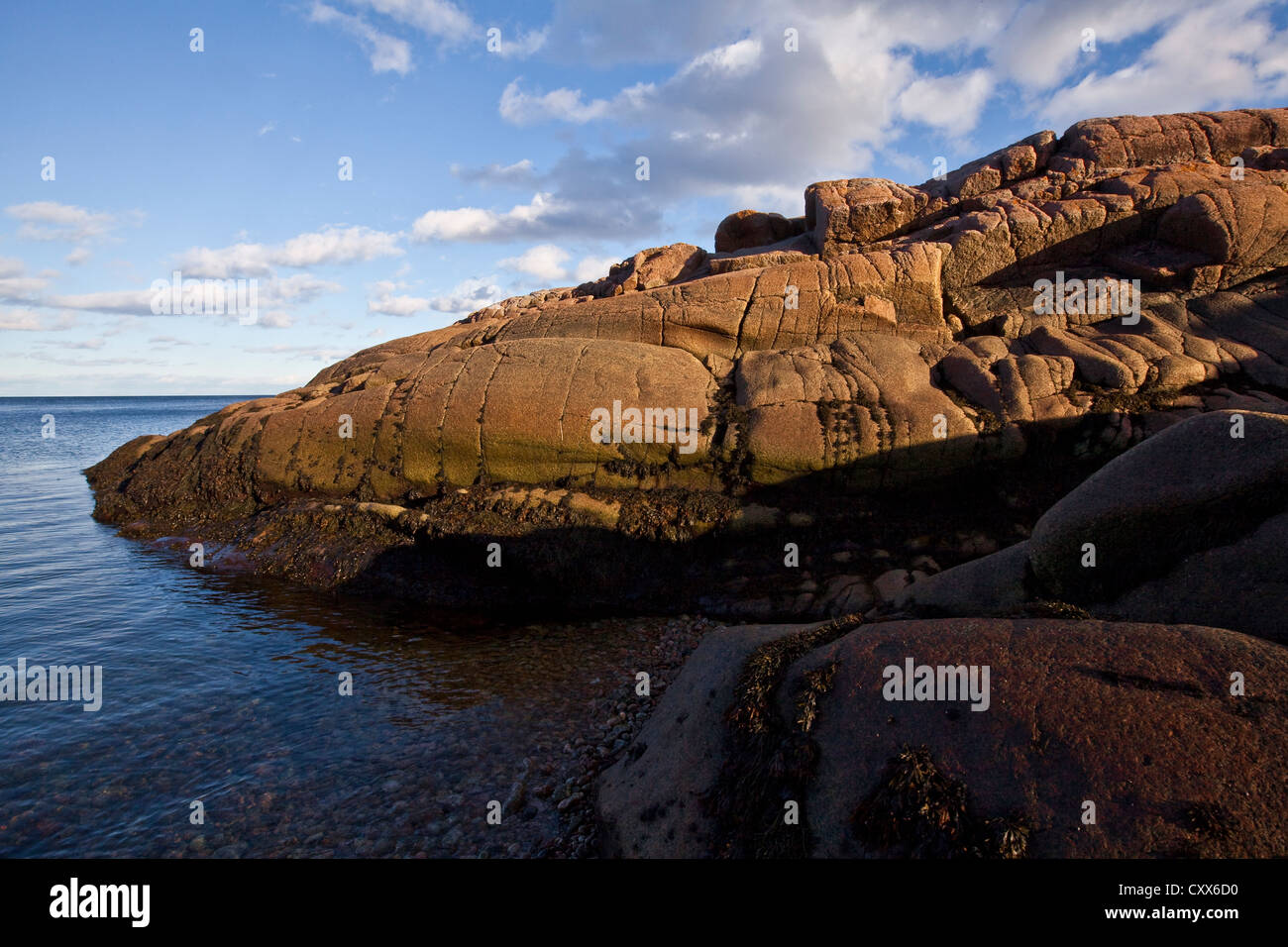The sun sets on the rocky seashore and the intertidal zone of the St ...