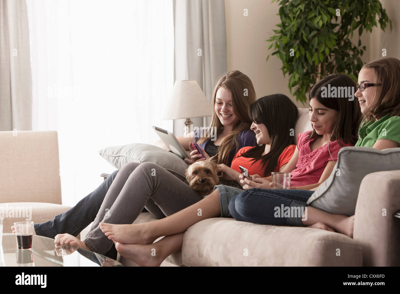 Friends hanging out on sofa together Stock Photo - Alamy