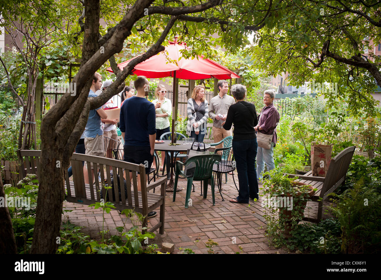 A docent, right in black, leads a tour of a community garden in the ...