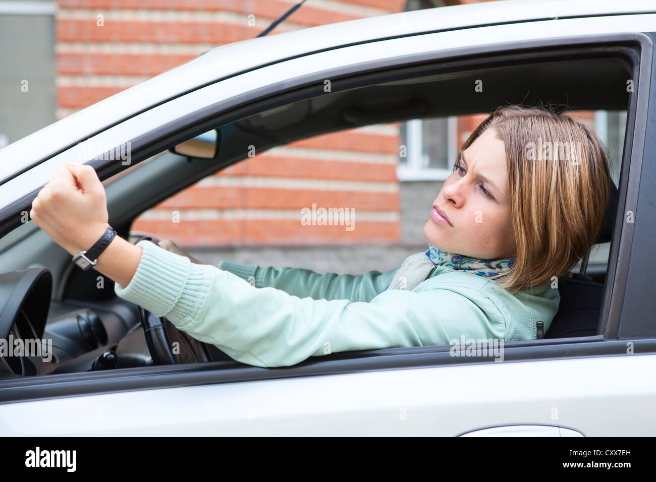 Young woman driver shaking her fist from car window Stock Photo - Alamy