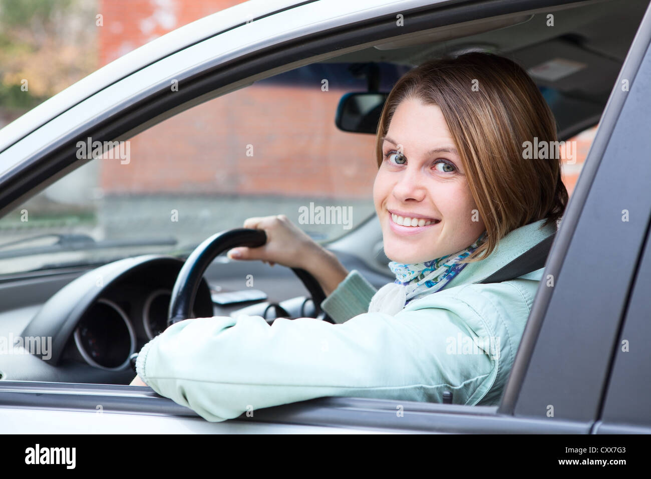 Female driver looking back from car window Stock Photo - Alamy