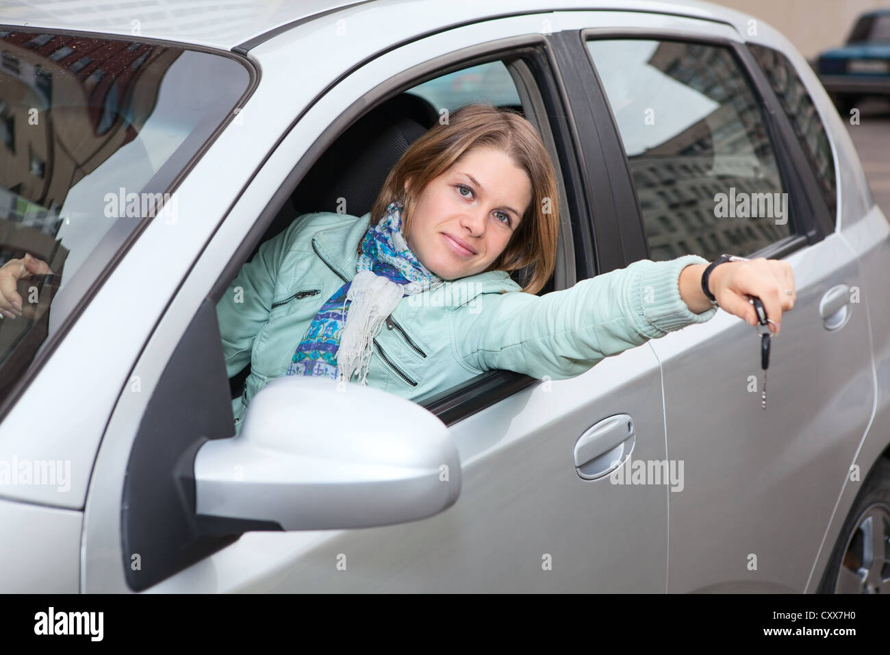 Happy blond with car key showing in window Stock Photo - Alamy