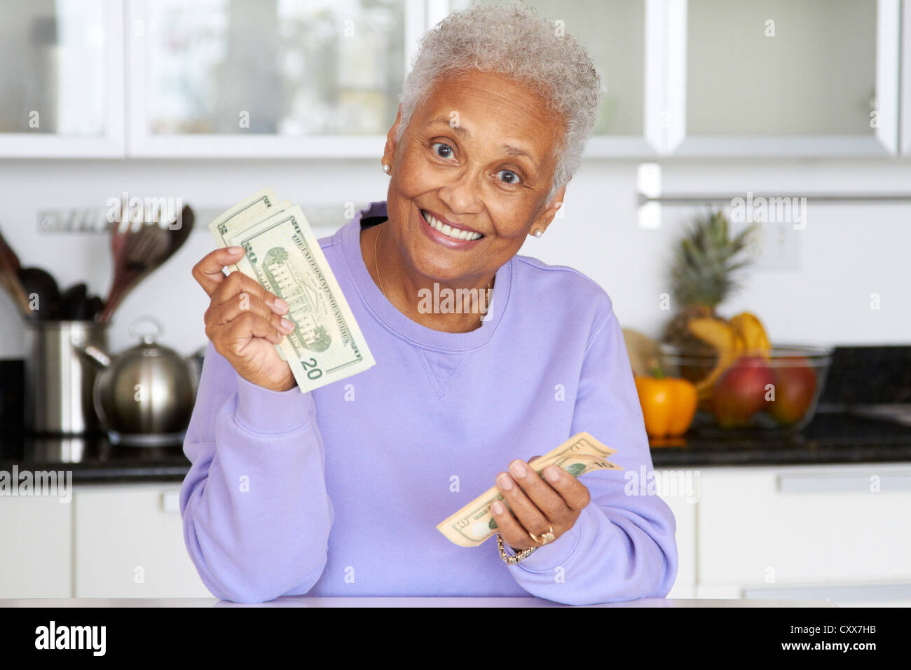 African American woman counting money in kitchen Stock Photo - Alamy
