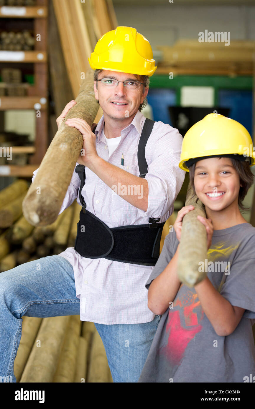 Hispanic father and son carrying lumber Stock Photo - Alamy
