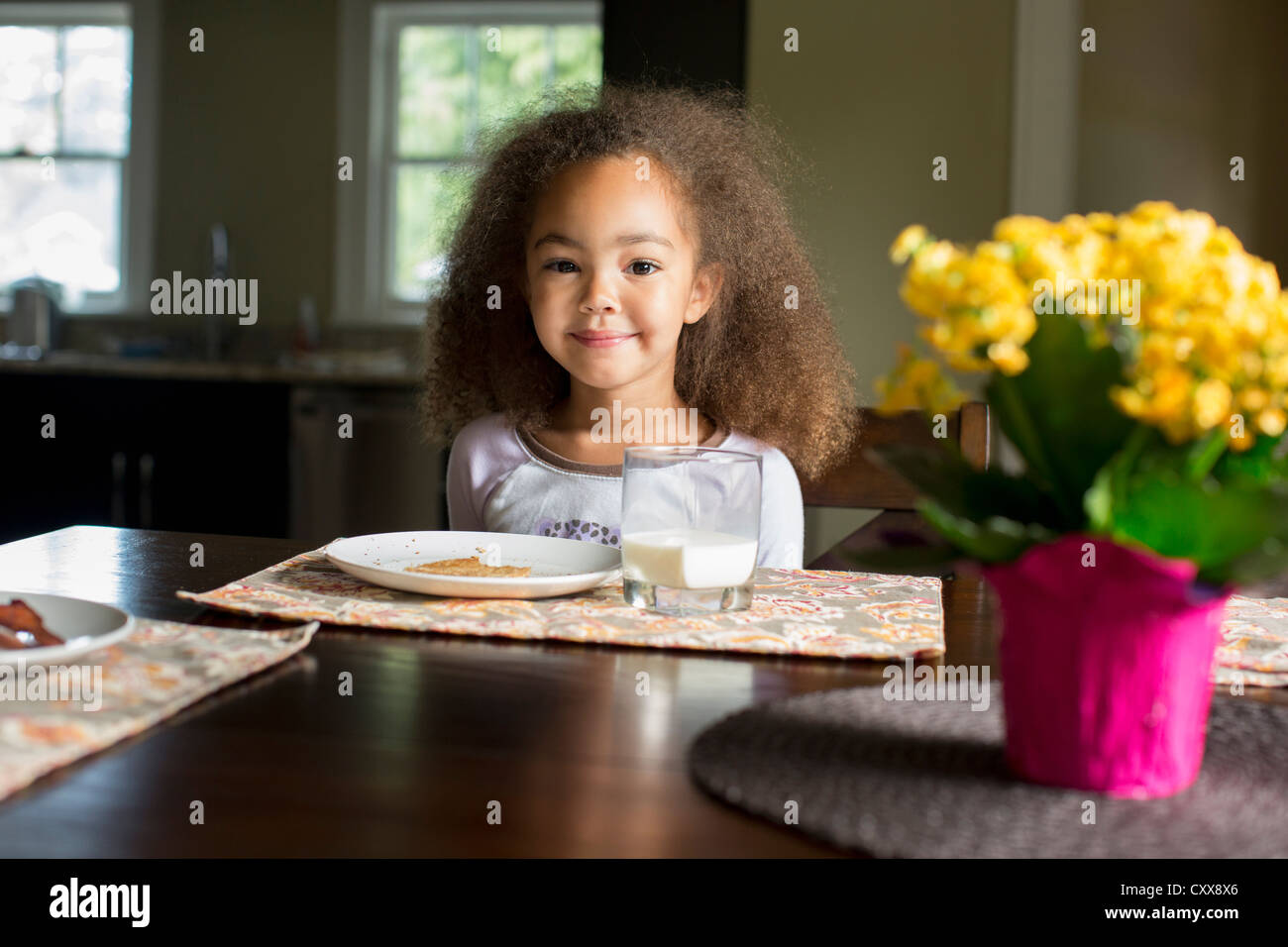 Mixed race girl eating breakfast Stock Photo - Alamy