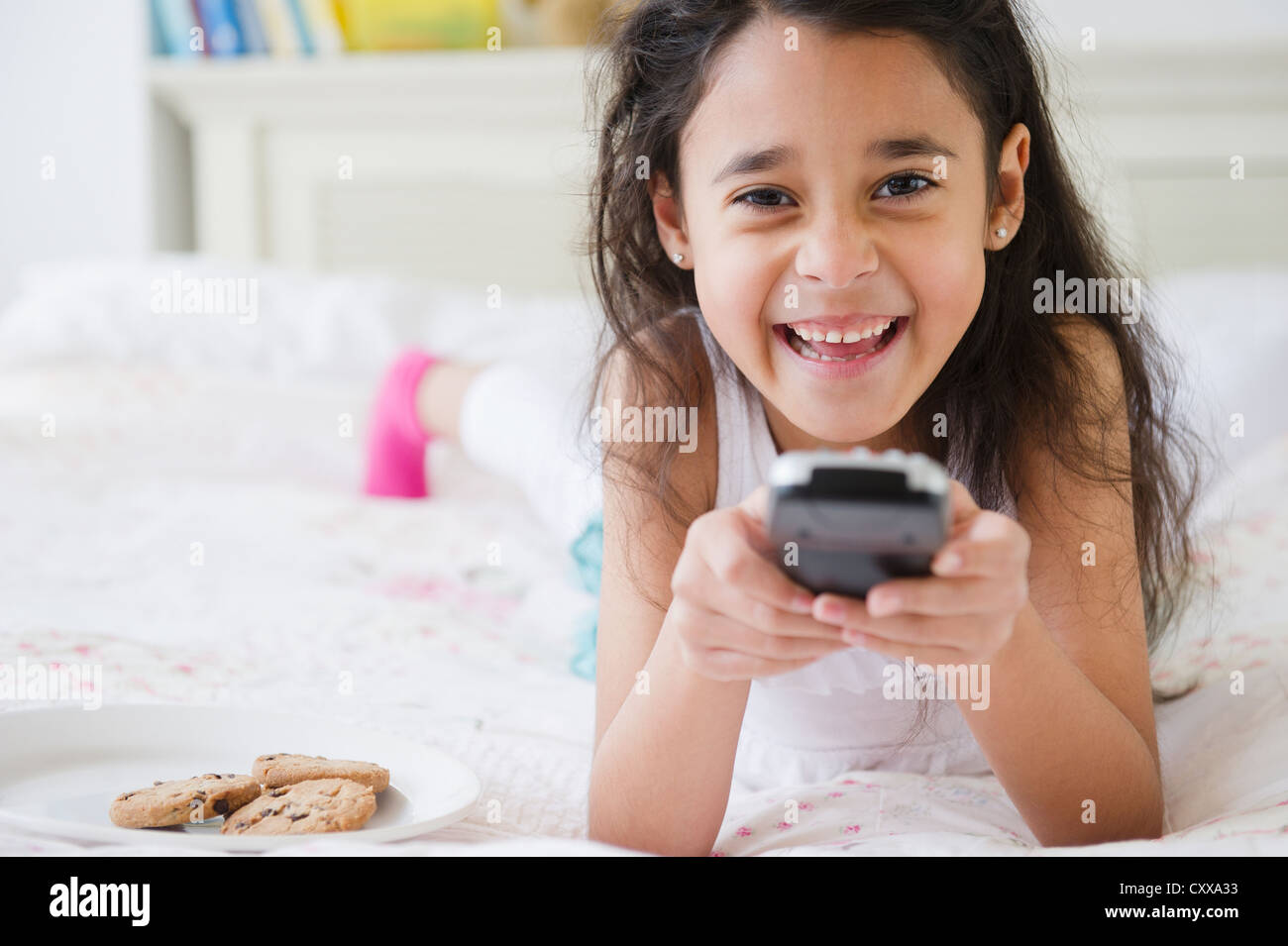 Happy girl holding remote hi-res stock photography and images - Alamy