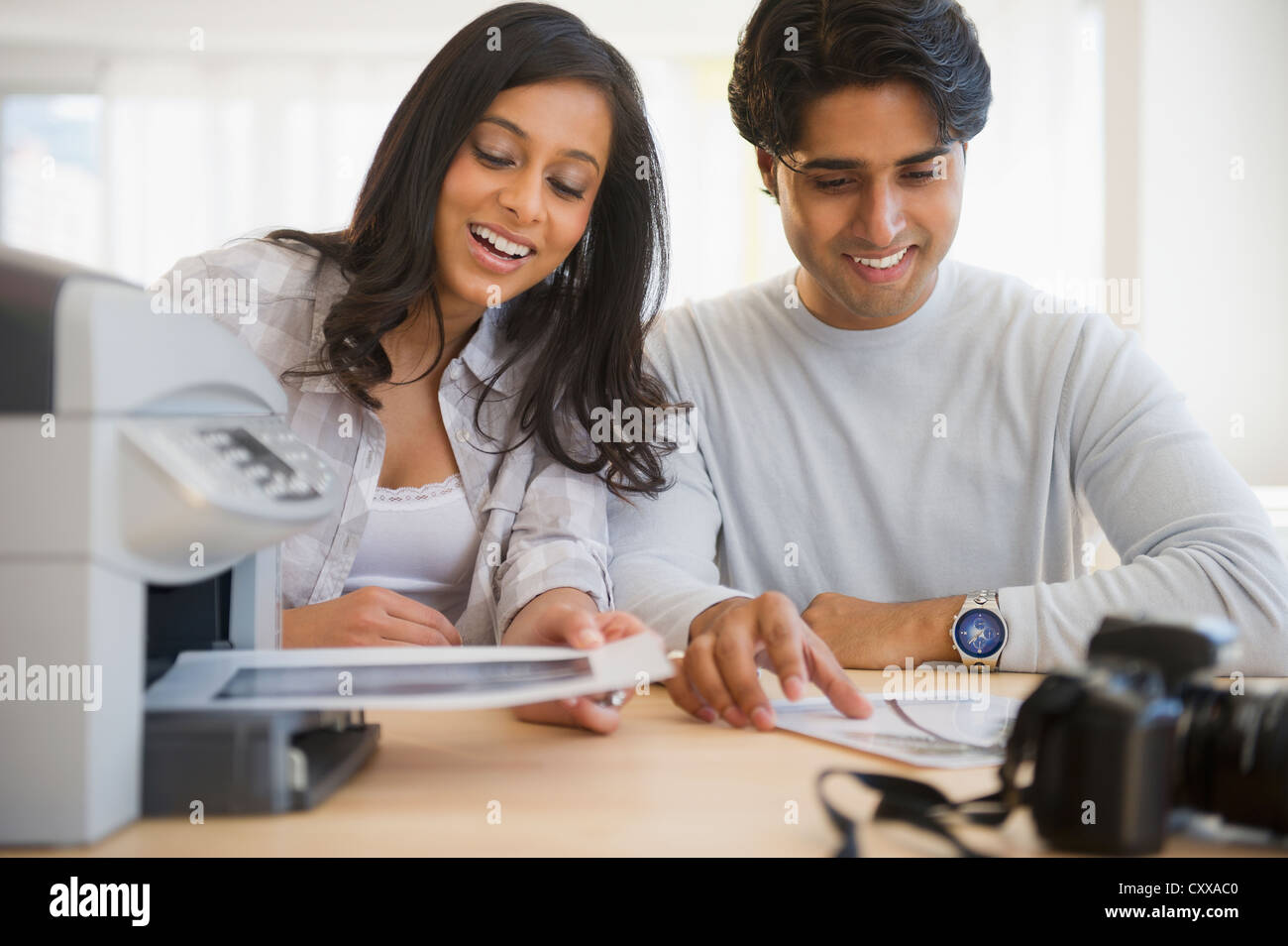 Mixed race couple printing documents Stock Photo - Alamy