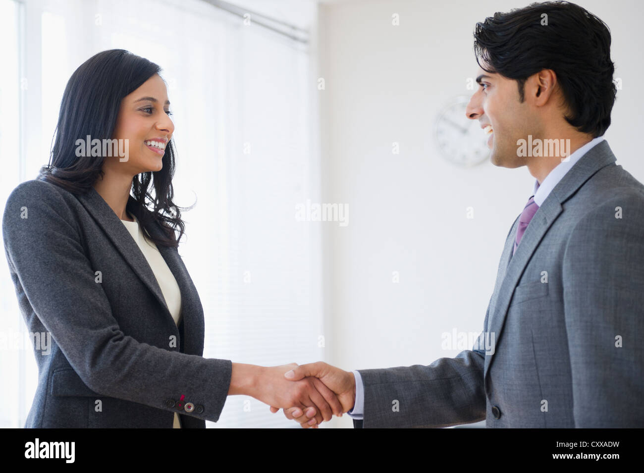 Mixed race business people shaking hands Stock Photo - Alamy