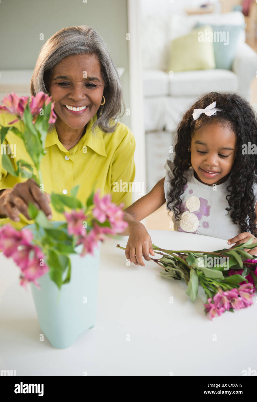 African American Grandmother And Granddaughter Arranging Flowers Stock