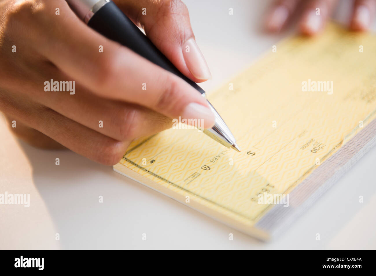 Cape Verdean woman writing a check Stock Photo - Alamy