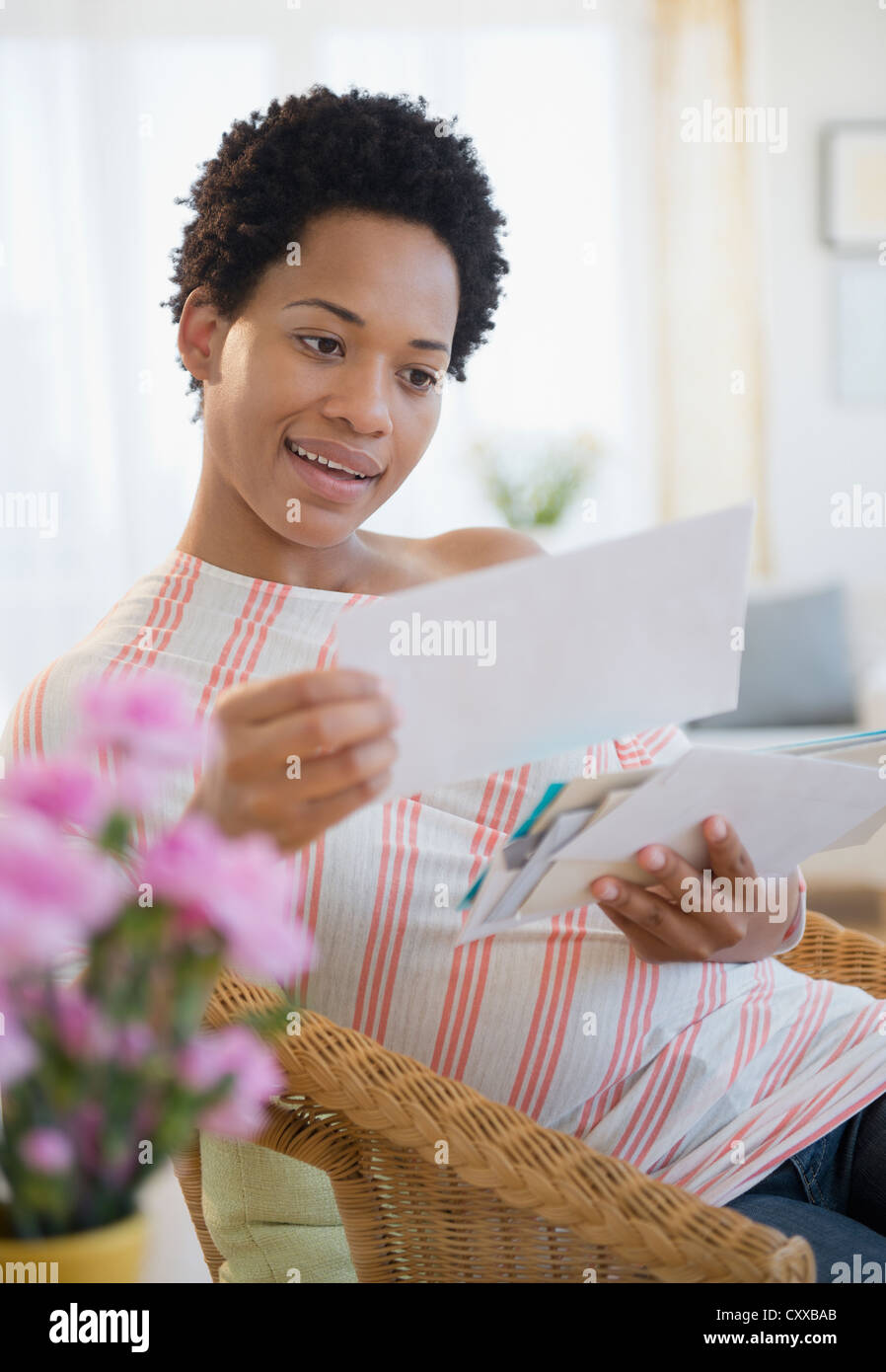 African American woman looking at mail Stock Photo - Alamy