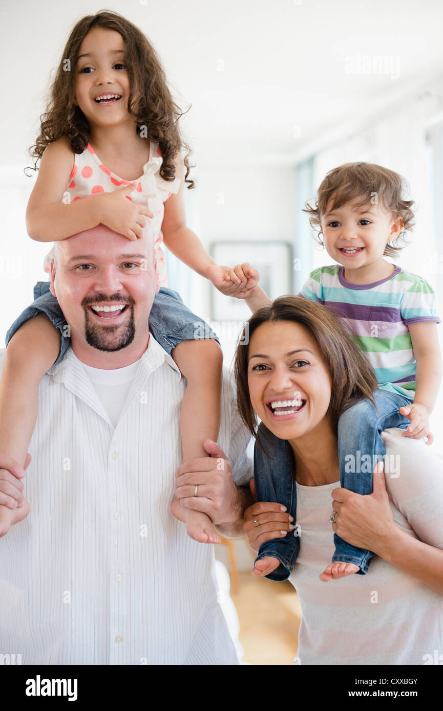Parents carrying children on shoulders Stock Photo - Alamy