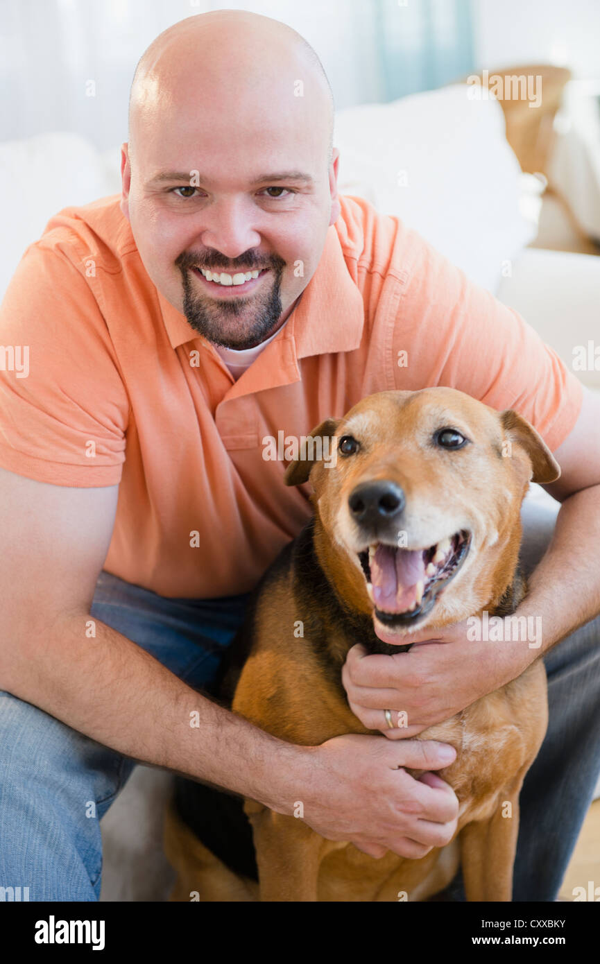 Smiling man hugging dog Stock Photo - Alamy