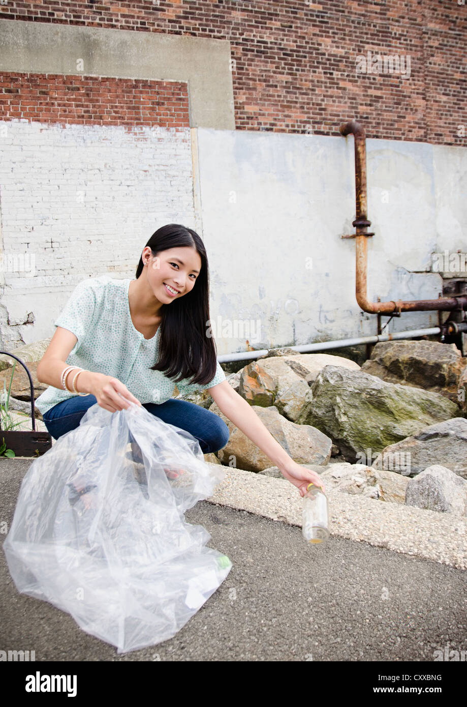 Asian woman picking up litter Stock Photo - Alamy