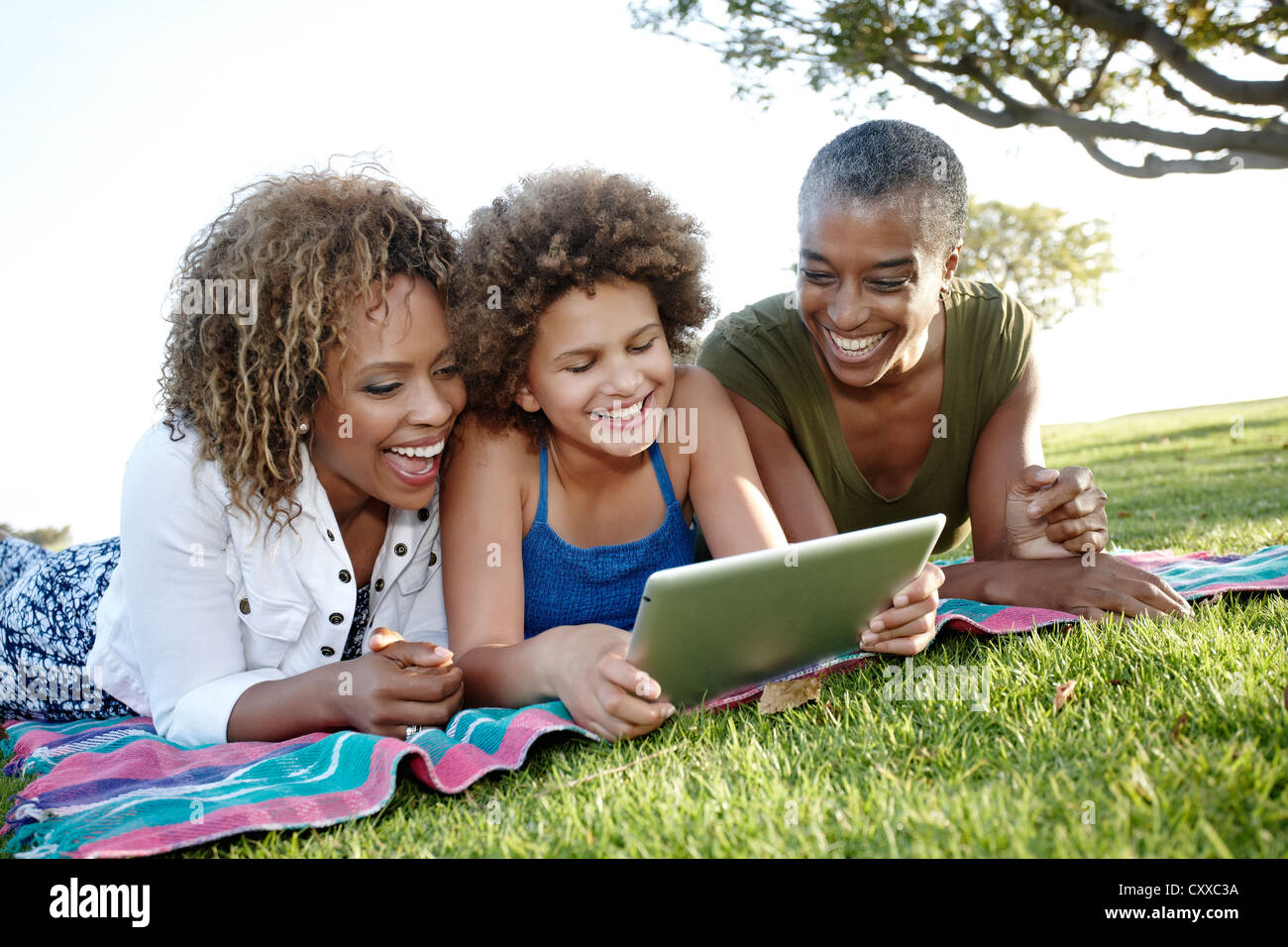 African American family using digital tablet in park Stock Photo - Alamy