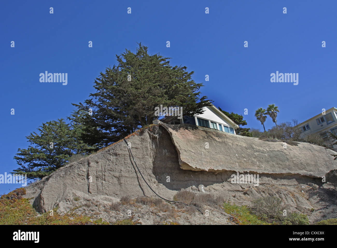 A house perched on the edge of an eroding cliff at Pismo Beach ...