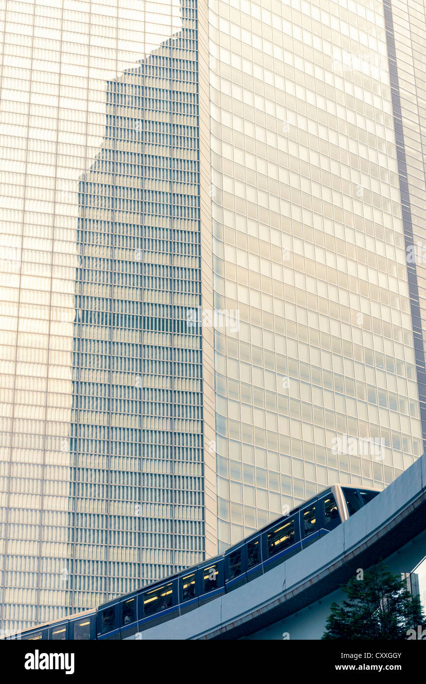train moving on hanged up railway under huge skyscrapers in central ...