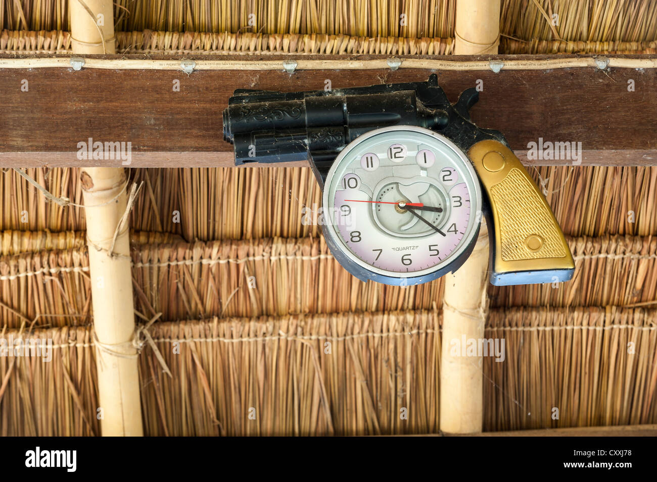 Clock in the shape of a revolver under a thatched roof, Northern ...