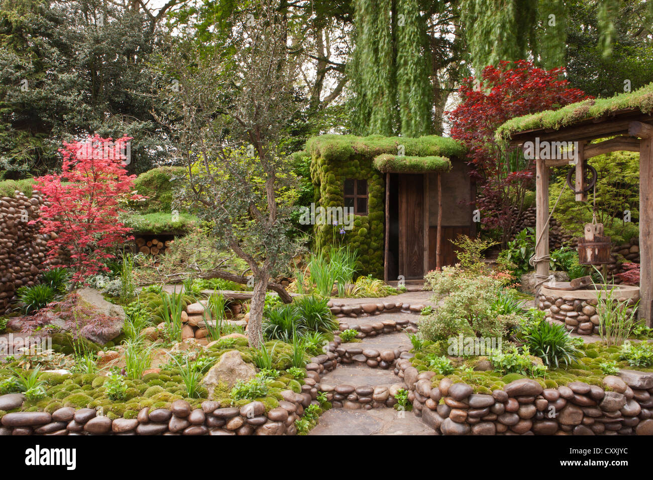 A small Japanese Zen garden with moss covered stones stone and water ...