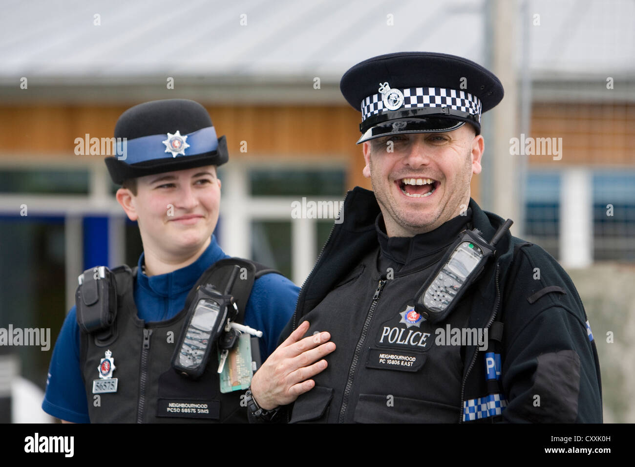 Smiling female police community support officer and laughing male ...