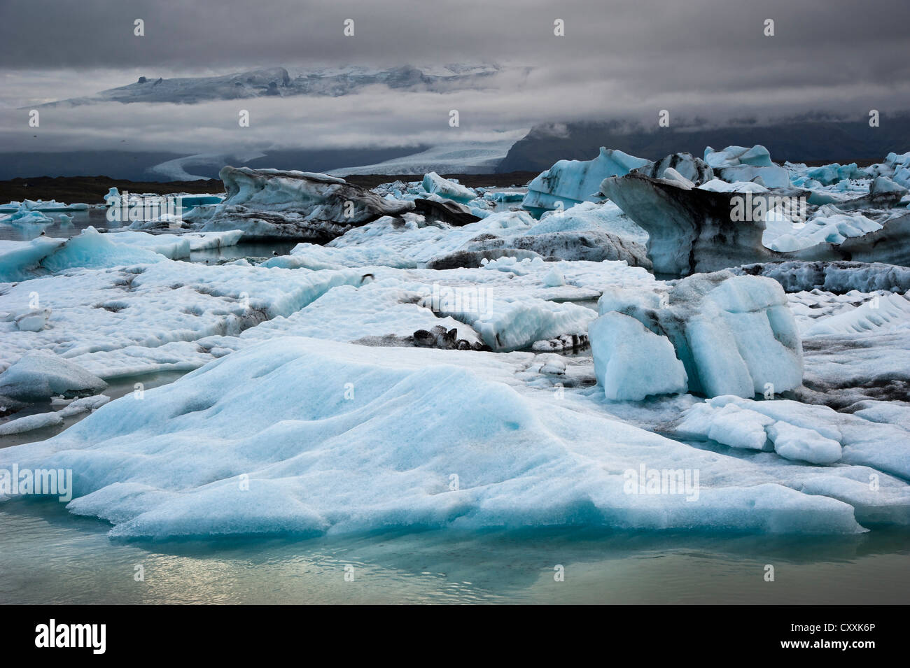 Blue and black ash-coloured icebergs, glacier lagoon of Joekulsárlón ...