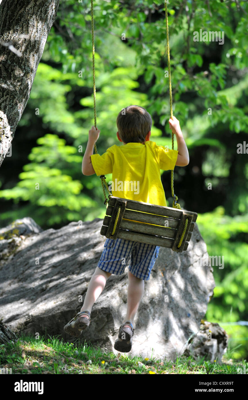 Boy on a swing, child on a swing Stock Photo - Alamy