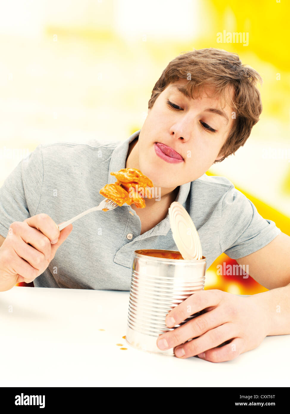 Young man eating ravioli from a tin can Stock Photo - Alamy