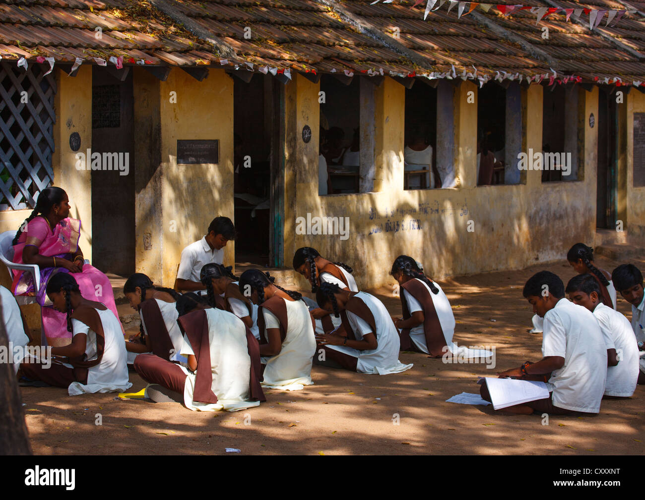 Group Of Students In Uniform Studying Sitting On The Ground In Front Of ...