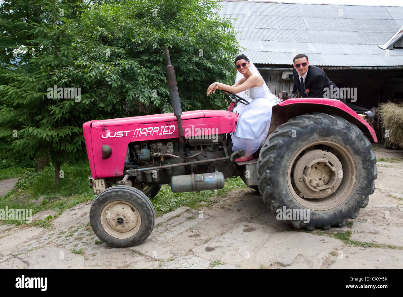 Bride and groom, bridal couple on a tractor Stock Photo - Alamy