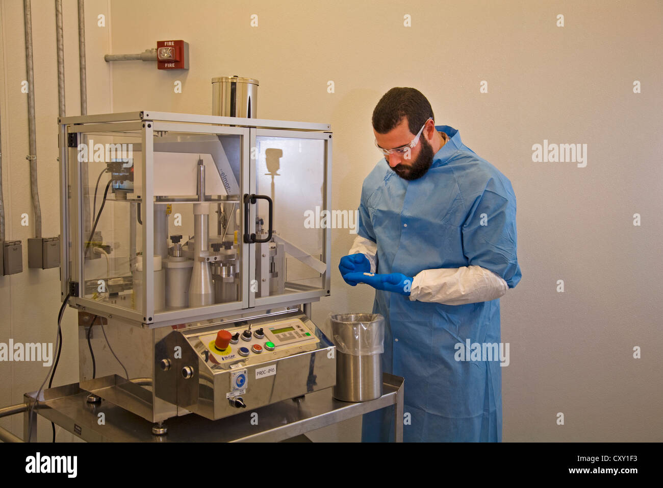 A chemist dressed in safety gear works in research at a at a ...