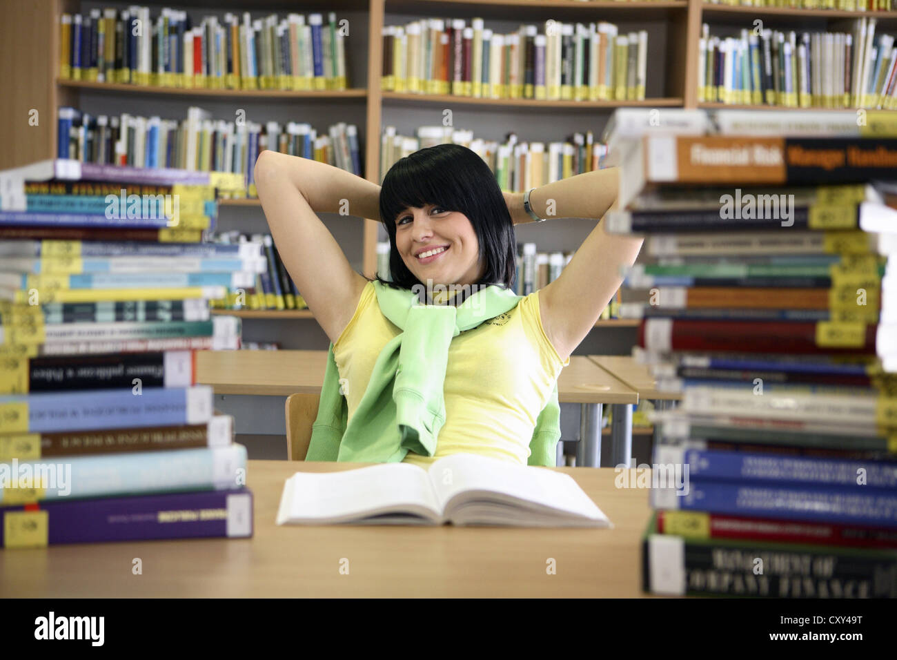 Satisfied student with stacks of books in a university library Stock ...